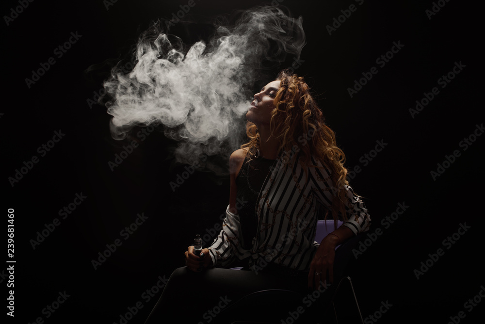 Redhead Woman Vaping Electronic Cigarette With Smoke On Black Background Closeup Young Woman