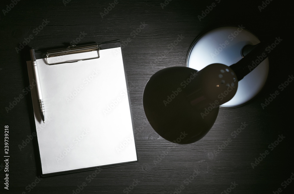 Blank paper page document with copy space and lamp on the black office ...