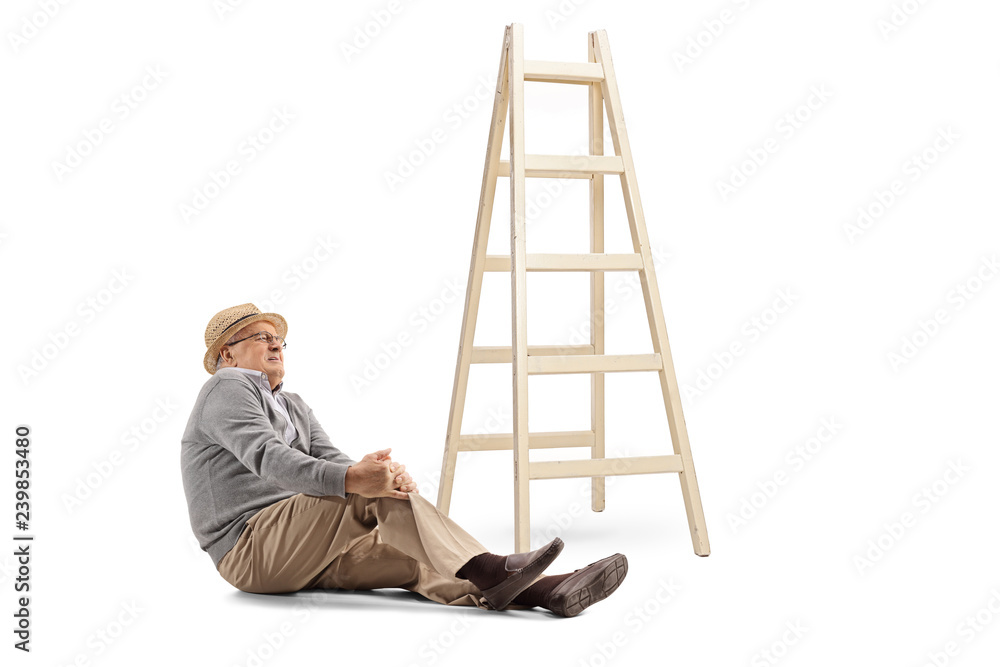 Elderly man fallen off a ladder sitting on the floor and holding his ...