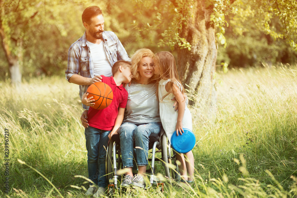 Family portrait. Woman in a wheelchair with her family outdoors. Stock ...