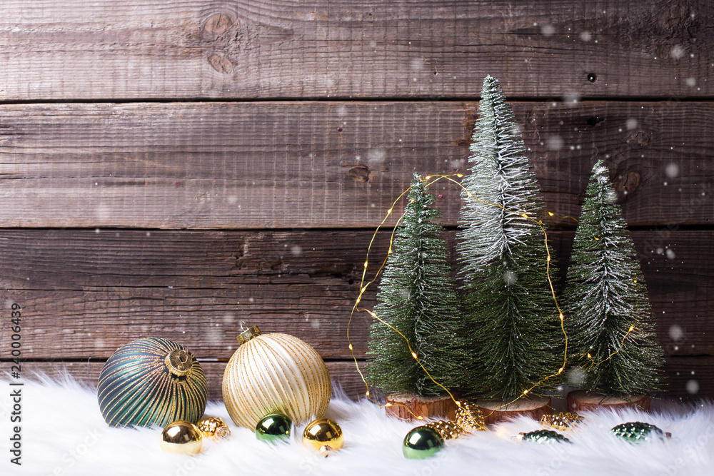 Decorative fir trees, golden and green balls and fairy lights on white ...