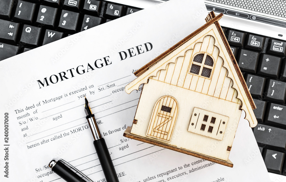 Mortgage deed with model of house on laptop keyboard. Top view. Stock ...