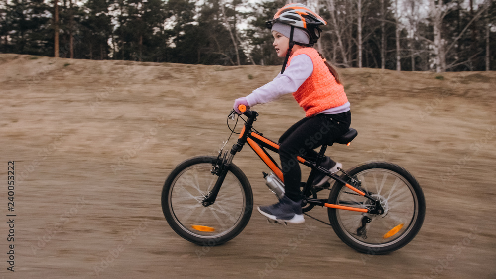 One caucasian children rides bike road track in dirt park. Girl riding ...