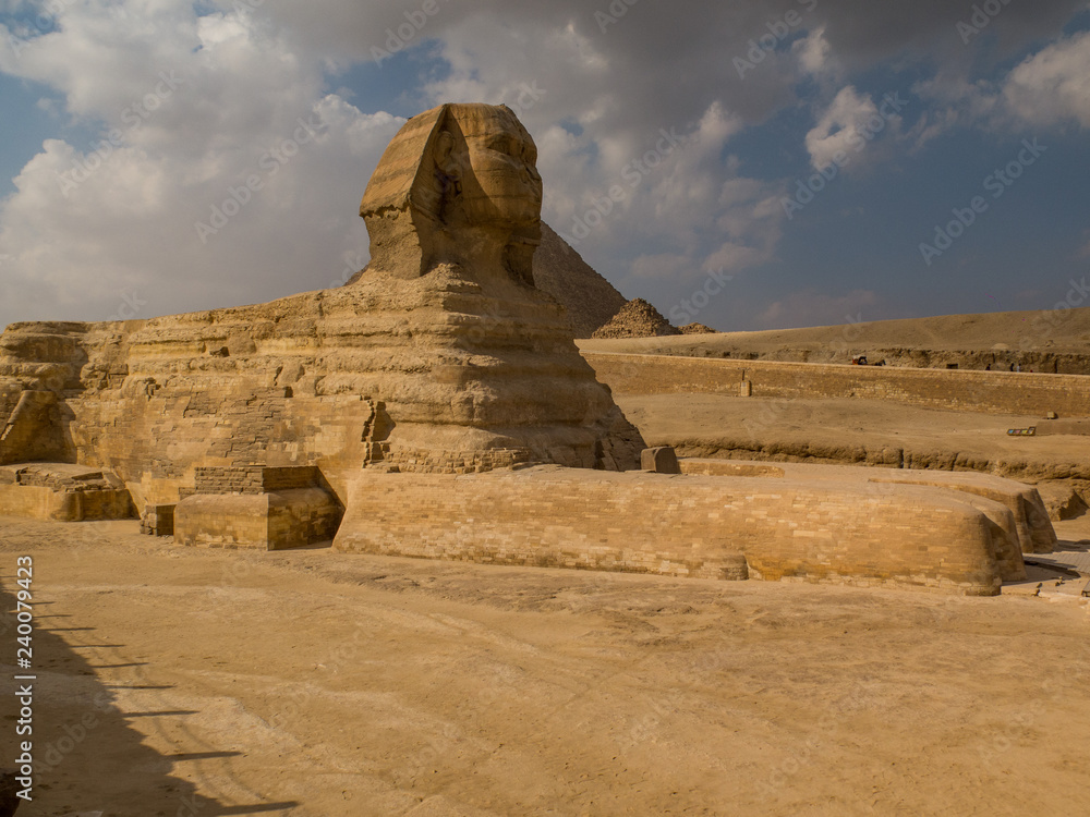 Side view of the Sphinx with its legs with the great pyramid behind it ...