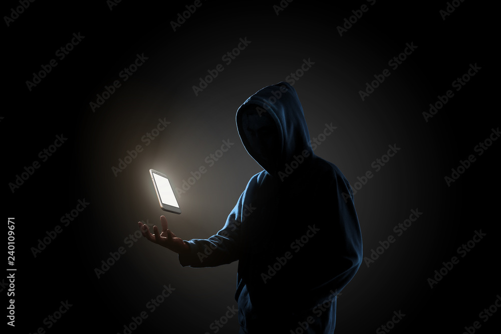 White smartphone floating above of hacker's hand in dark background ...