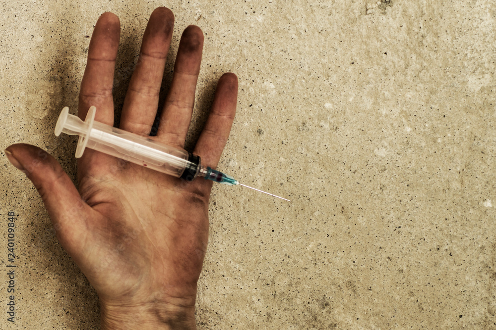 Hand of drug addicted on a grey cement background. Anti drug concept ...