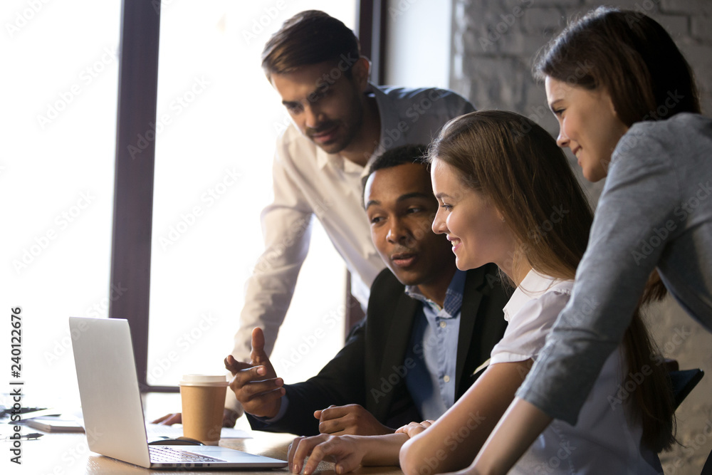 Smiling diverse office workers using laptop discussing online project ... Smiling diverse office workers using laptop discussing online project ...