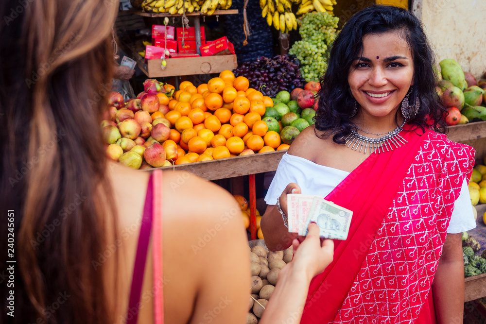 travel girl seller in street market and a buyer in a fruit shop in ...