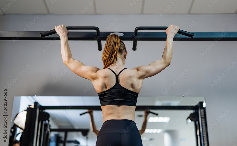 Back view of a woman with hair in pony tail doing workout tightening on ...