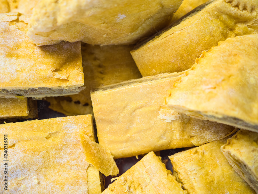 Closeup photograph of Jamaican beef patties with flaky yellow crust and ...