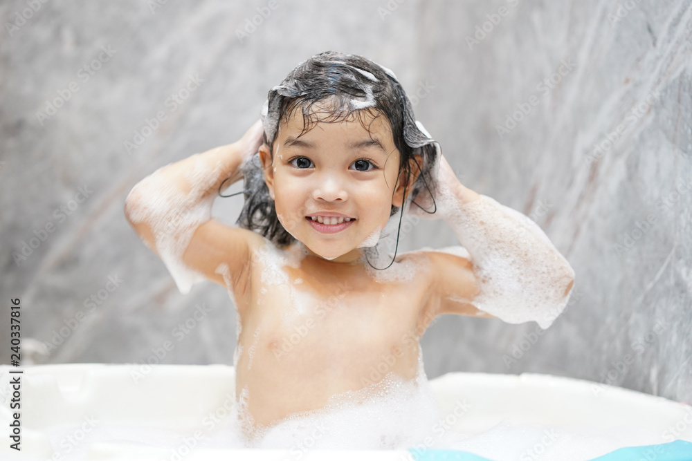 Asian kid bathing concept. adorable girl in bathtub with fluffy soap ...