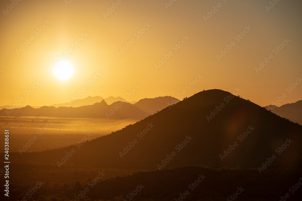 The sun rising over the mountains of the Arizona desert with natural ...