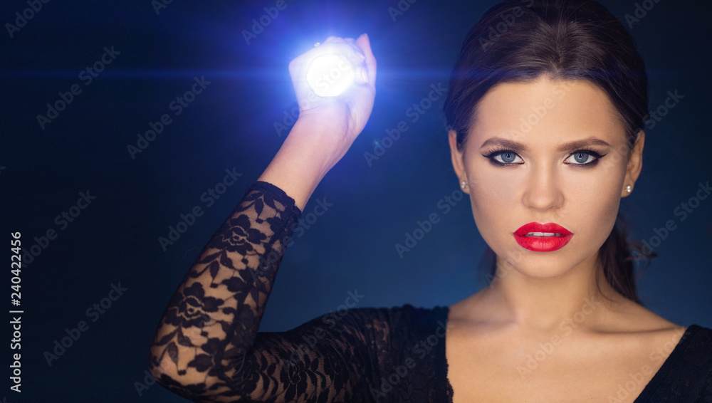 the girl with the led flashlight in her hands shines straight. glare of ...