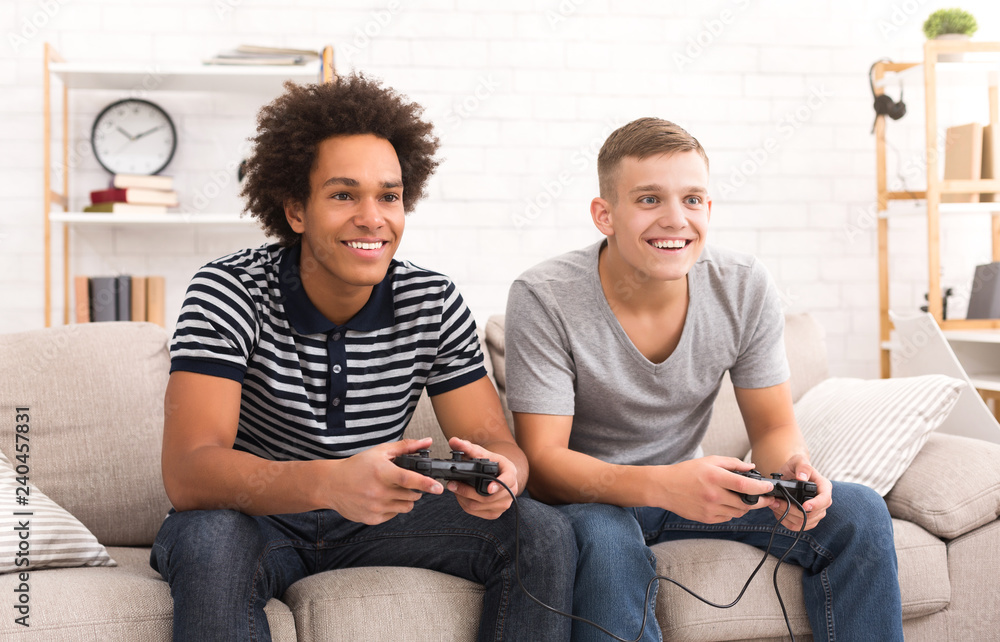 Diverse teenage boys playing game console at home Stock Photo | Adobe Stock