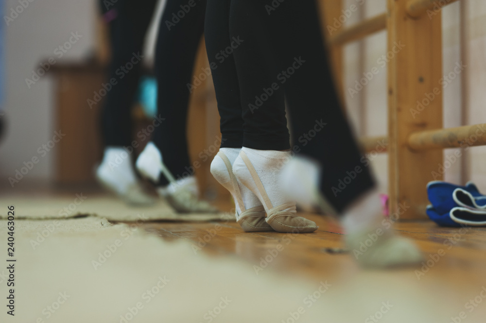 Close up of feet of young gymnast stretching tip toes at the gym club ...