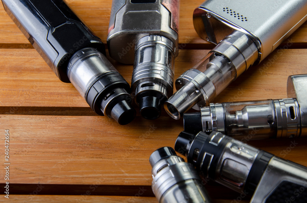 Popular vaping e cig devices mod.electronic cigarette over a wood ...