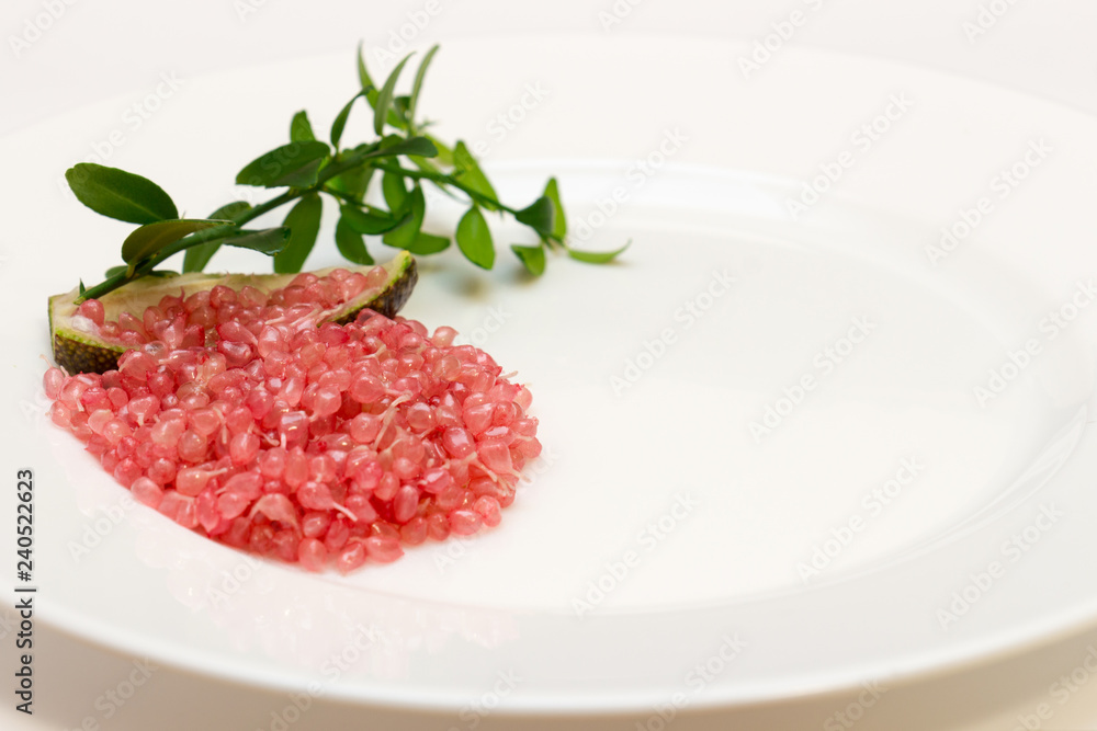 Delicious citrus caviar on a white plate decorated with a green sprig ...
