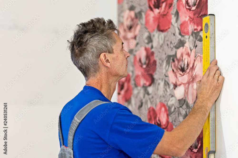 Construction worker observing and surveying wall alignment using water ...