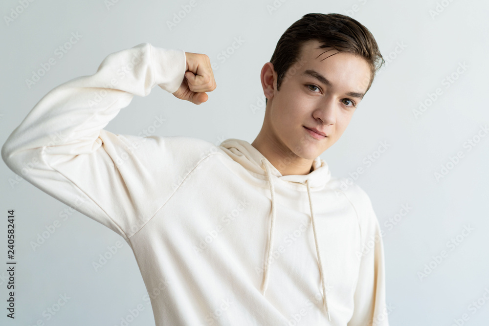 Content teen boy pumping fist and showing strength. Handsome young guy ...