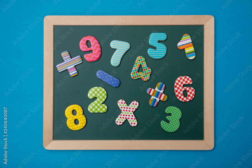 Green chalkboard with wooden frame, colorful math operation signs and ...