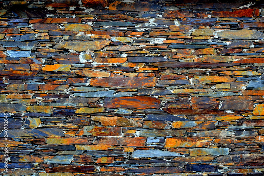 Close-up detail view of an old traditional stone wall built from schist ...
