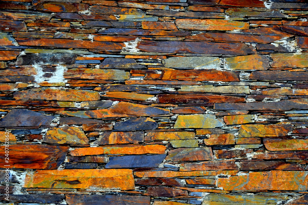 Close-up detail view of an old traditional stone wall built from schist ...