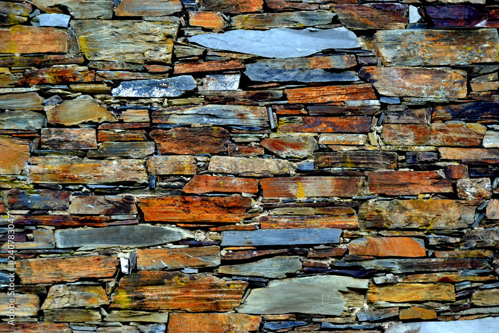 Close-up detail view of an old traditional stone wall built from schist ...