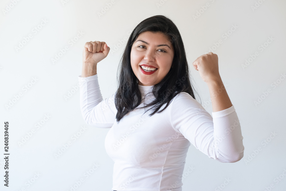 Positive successful feminist showing hand muscles. Cheerful young Asian ...