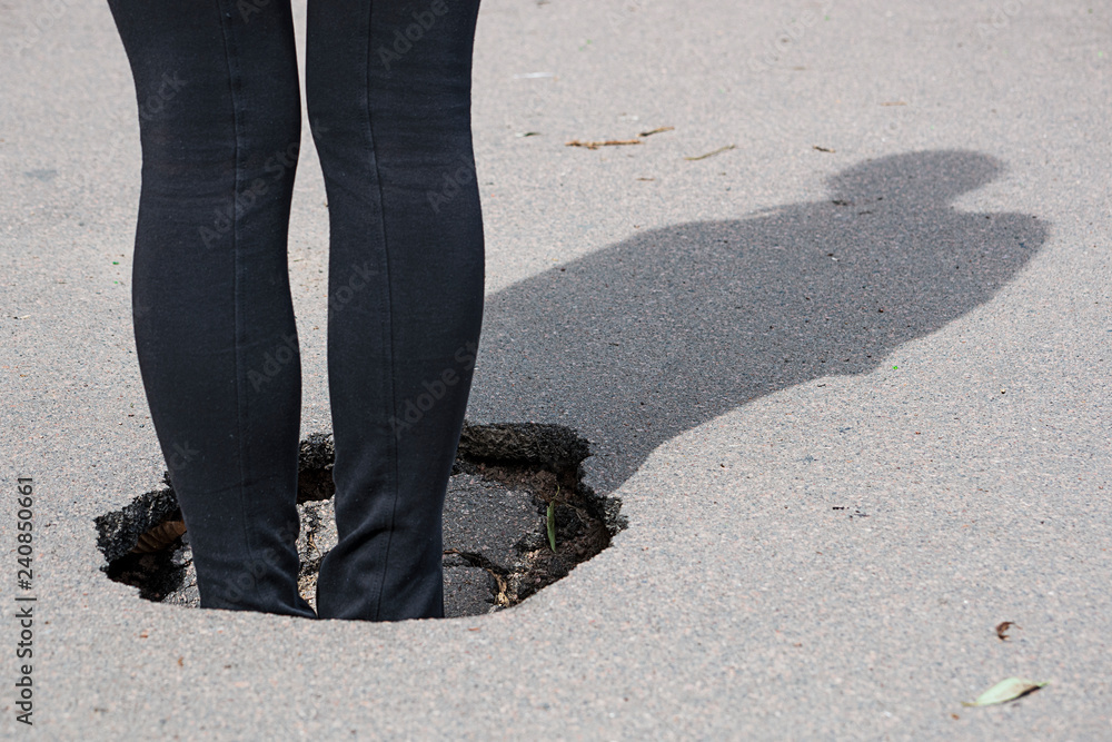 Female legs in a hole in the asphalt Stock Photo | Adobe Stock