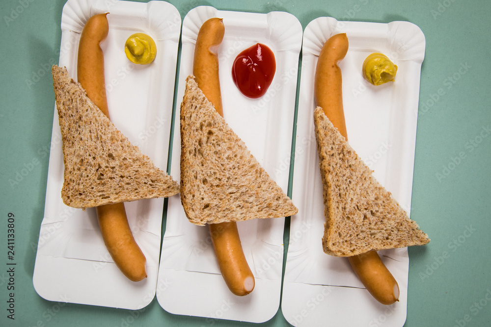 Drei Wiener Würstchen mit Vollkorn Brot Scheibe auf Einweg Pappteller ...