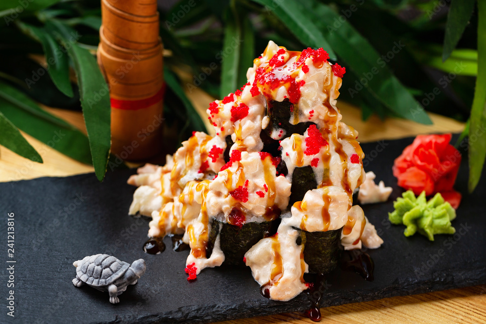 Plate of volcano sushi rolls with lava sauce at decorated with green ...