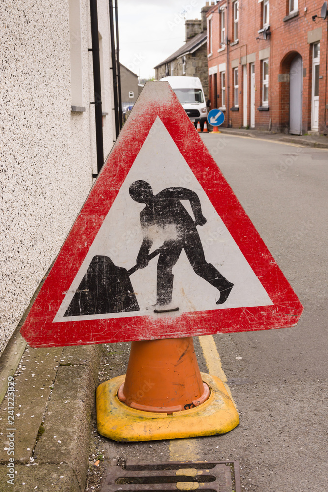 Battered road works sign in an urban terraced street in the United ...