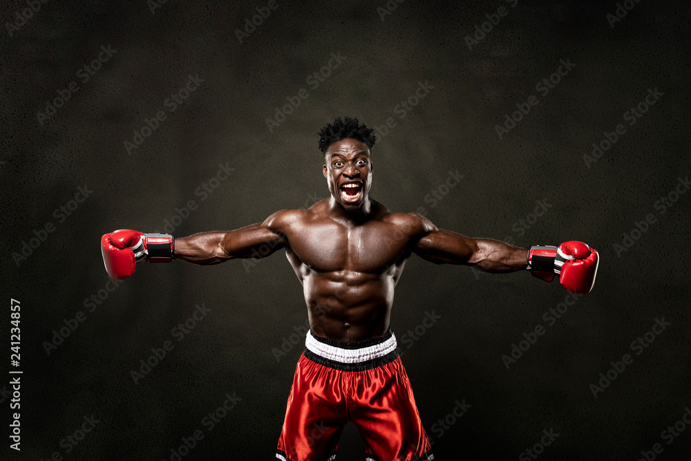 Muscular African American Black male sweaty boxer does an aggressive ...