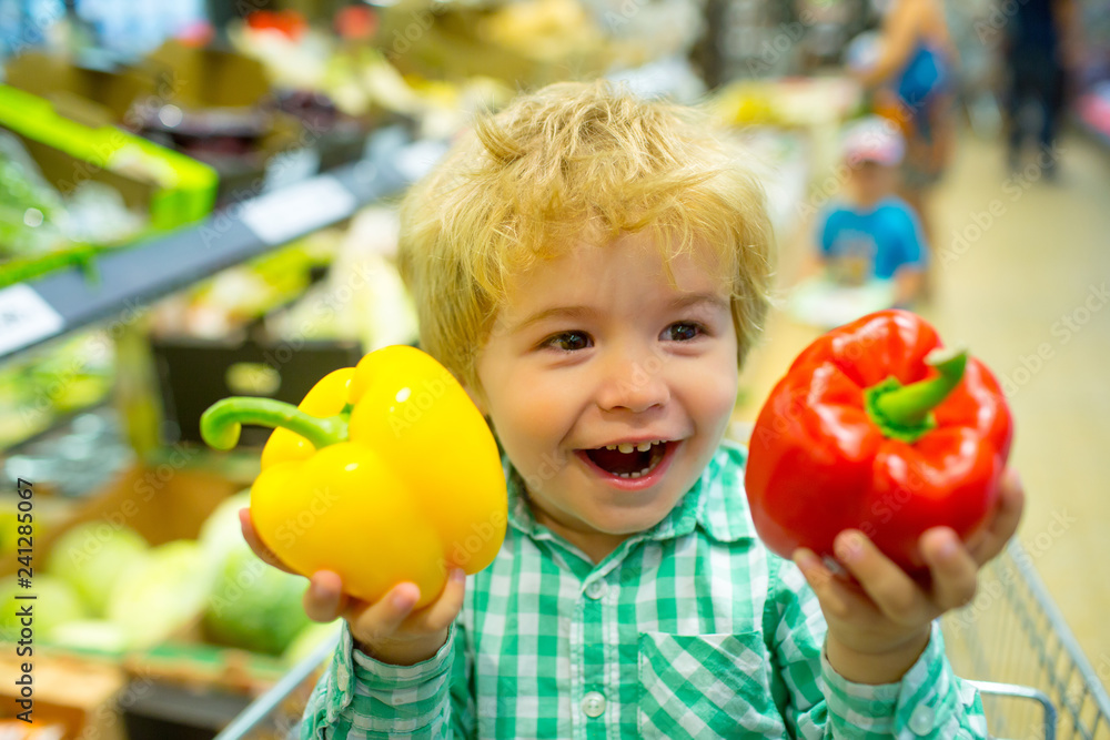 Healthy lifestyle. Adorable little boy in supermarket shows his sincere ...