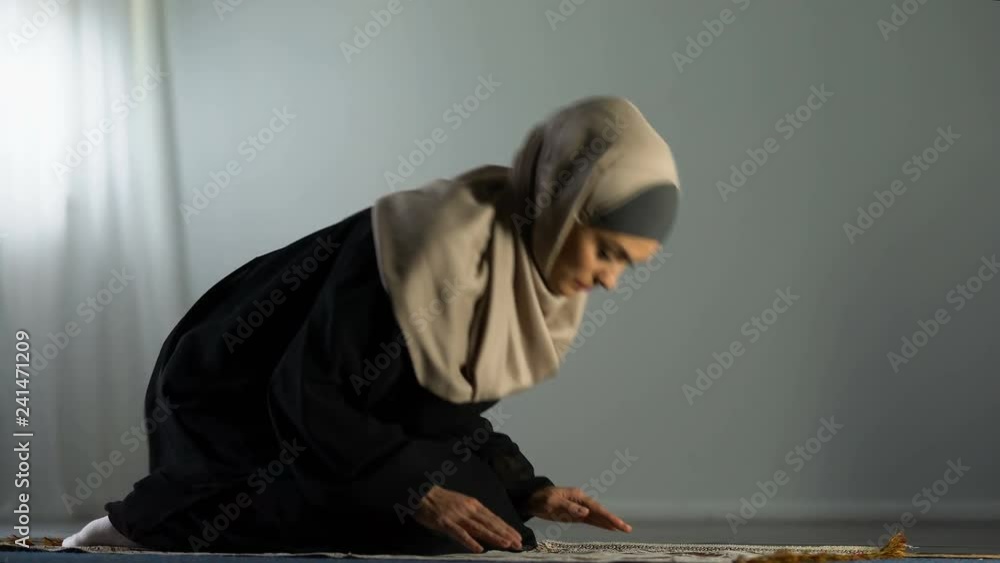 Kneeling arab woman prostrating on islamic praying rug, religious ...