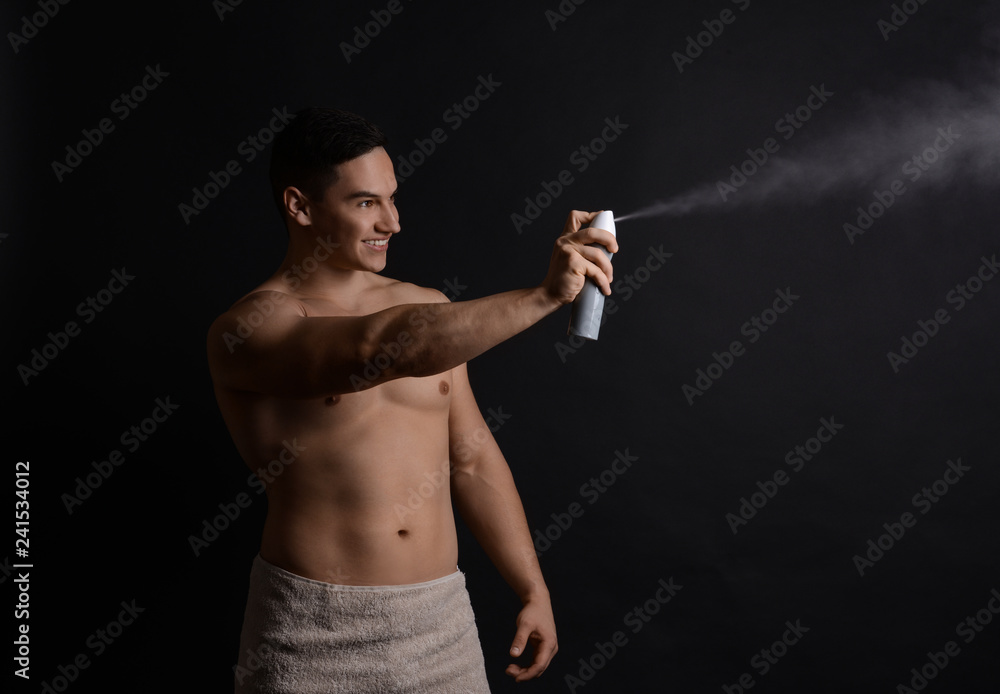 Young man with deodorant on dark background Stock Photo | Adobe Stock