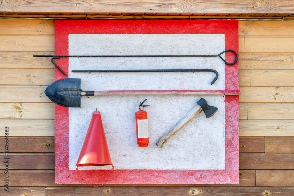 Wall-mounted fire shield with fire-fighting tools. Shovel, hook , axe ...