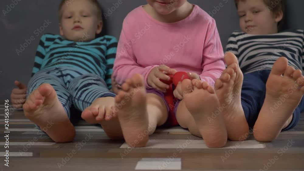 Cheerful children in multi-colored striped clothes are engaged in ...