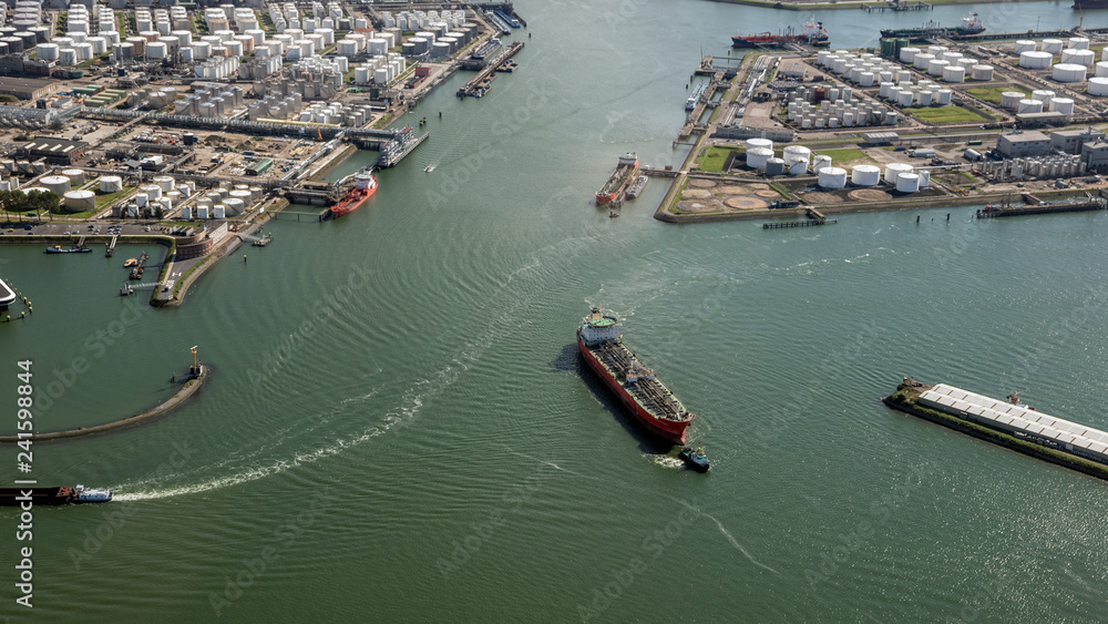 Aerial view of oil tankers moored at an oil storage silo terminal port ...
