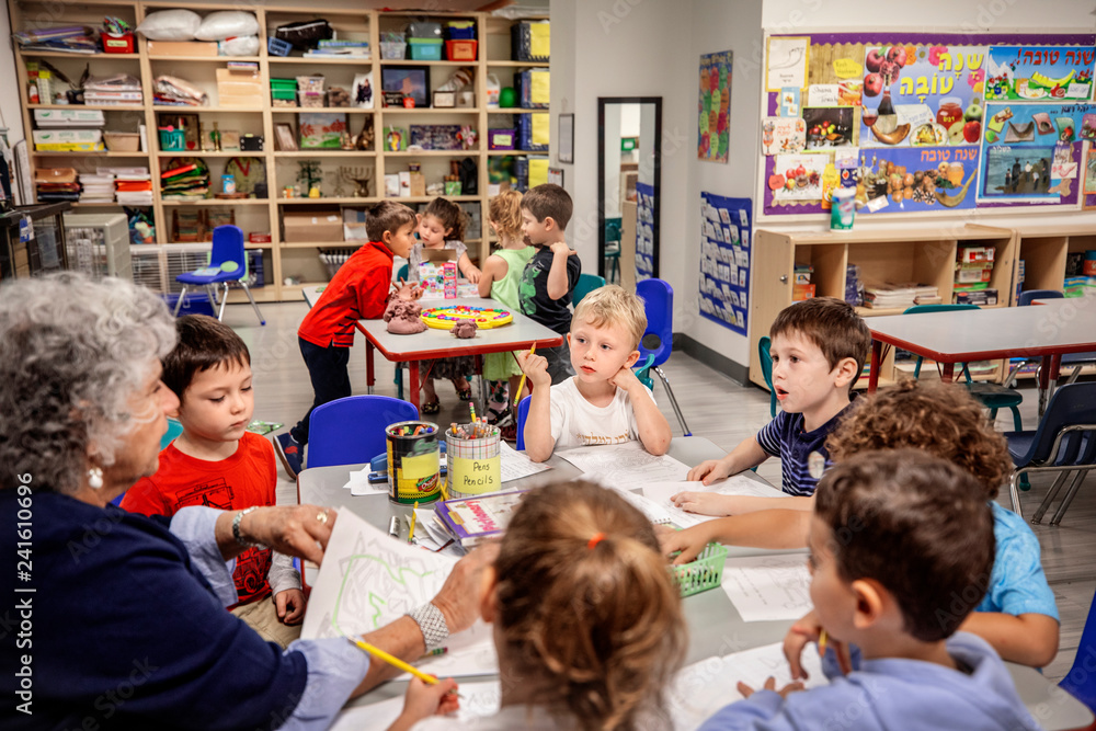 Teacher and children in a classroom Stock Photo | Adobe Stock