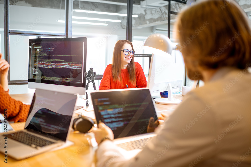 Team of a young programmers dressed casually working on computer code ...