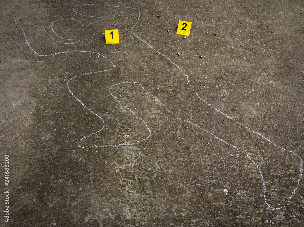 Crime scene. Shape of body on concrete texture. Bullet shell next to ...