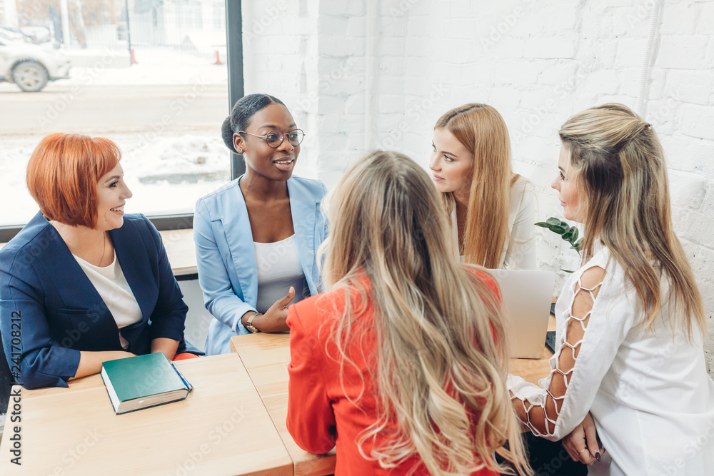 Team work process. Multiracial group of young women collaborating in ...