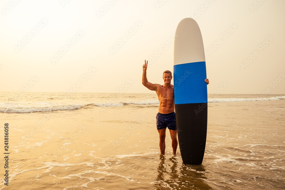 Poster surfing freelancing man is standing with a surf in his hands on ...