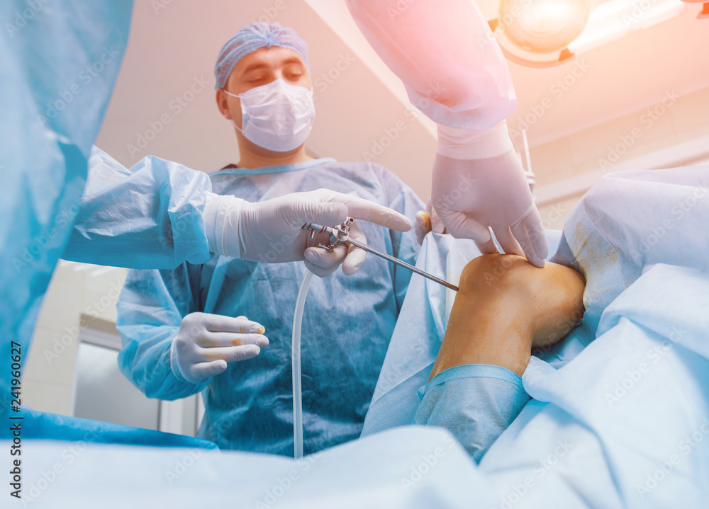 Arthroscope surgery. Orthopedic surgeons in teamwork in the operating ...