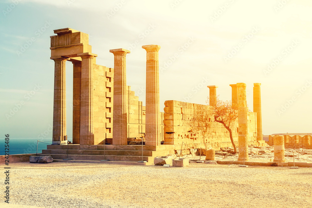 Ancient Greek acropolis. Front view of columns and walls. near the tree ...