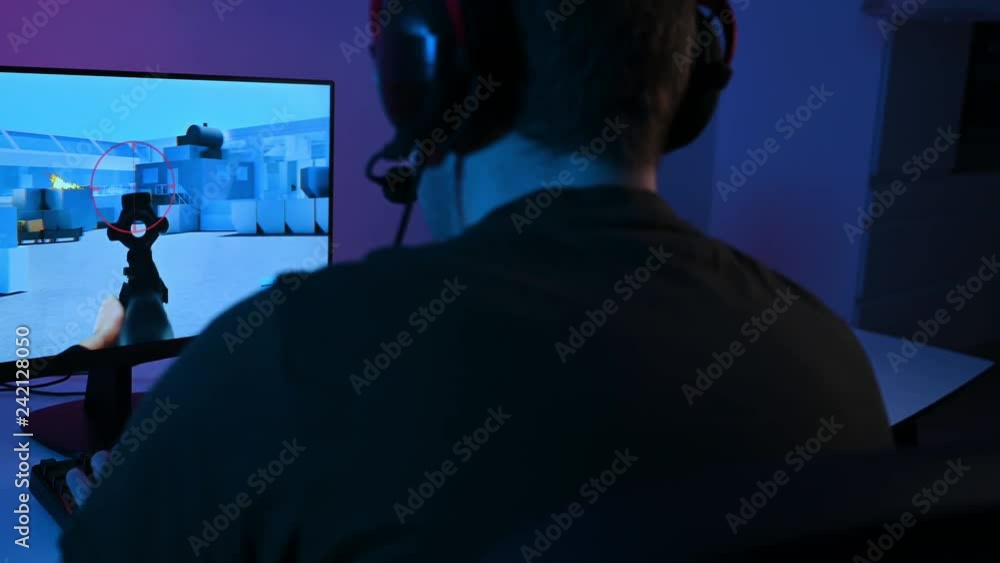 First person shooter video game on pc played by gamer with headset ...