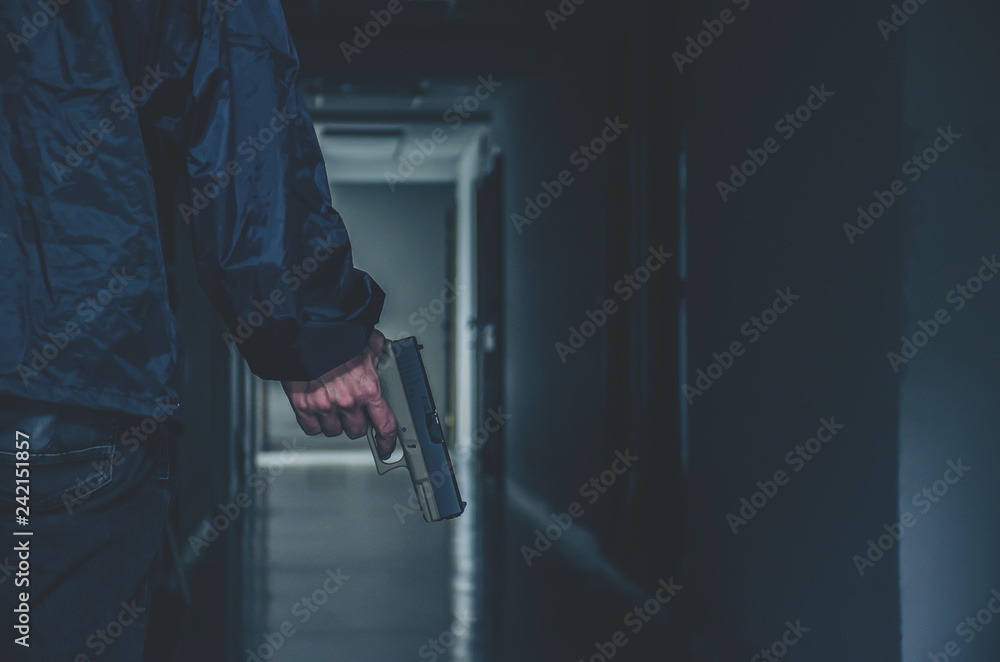 Robber or gangster,thief holding gun in hand side him ready to shoot ...
