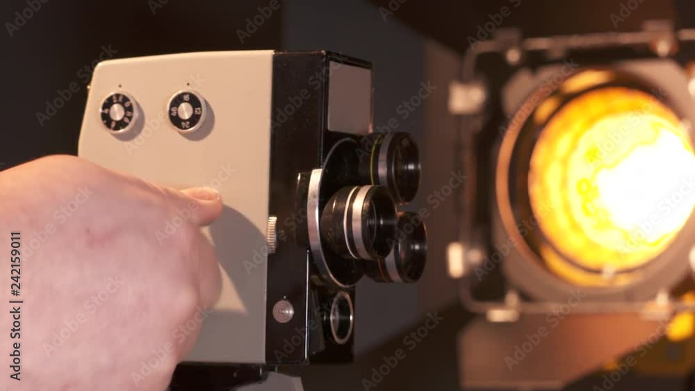 Man filming with vintage 8mm film movie camera. Winding and starting ...