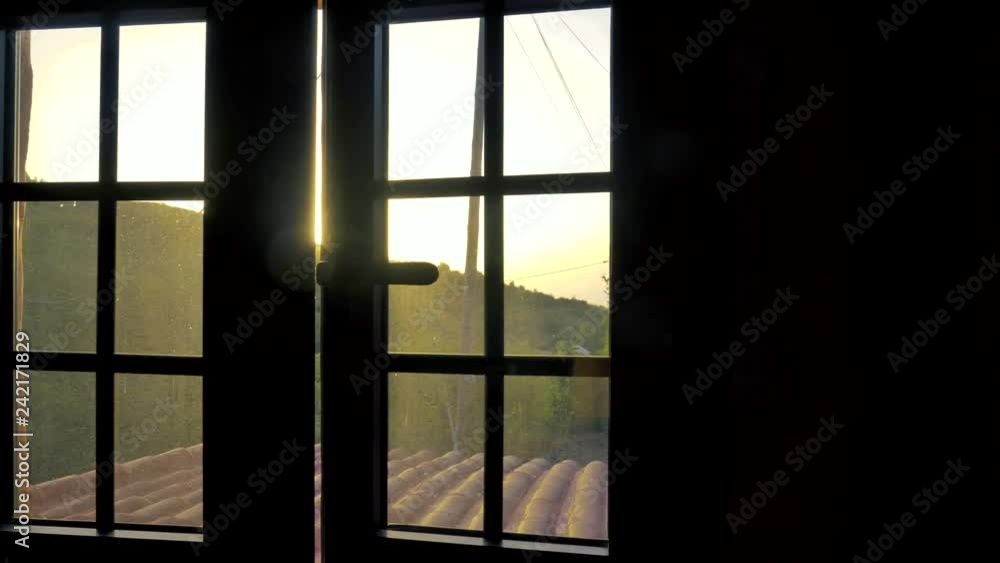Sun breaking over a ridge outside a window. Bright sunlight streaming ...